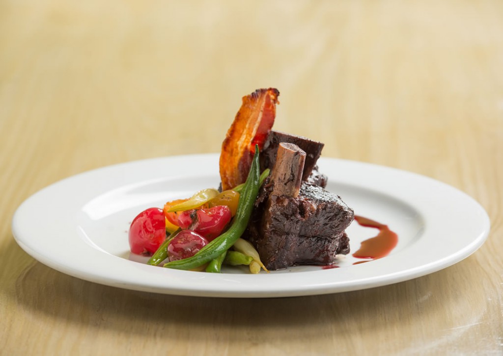 Malbec-flavored veal ribs with bacon, green beans and small Andean ...